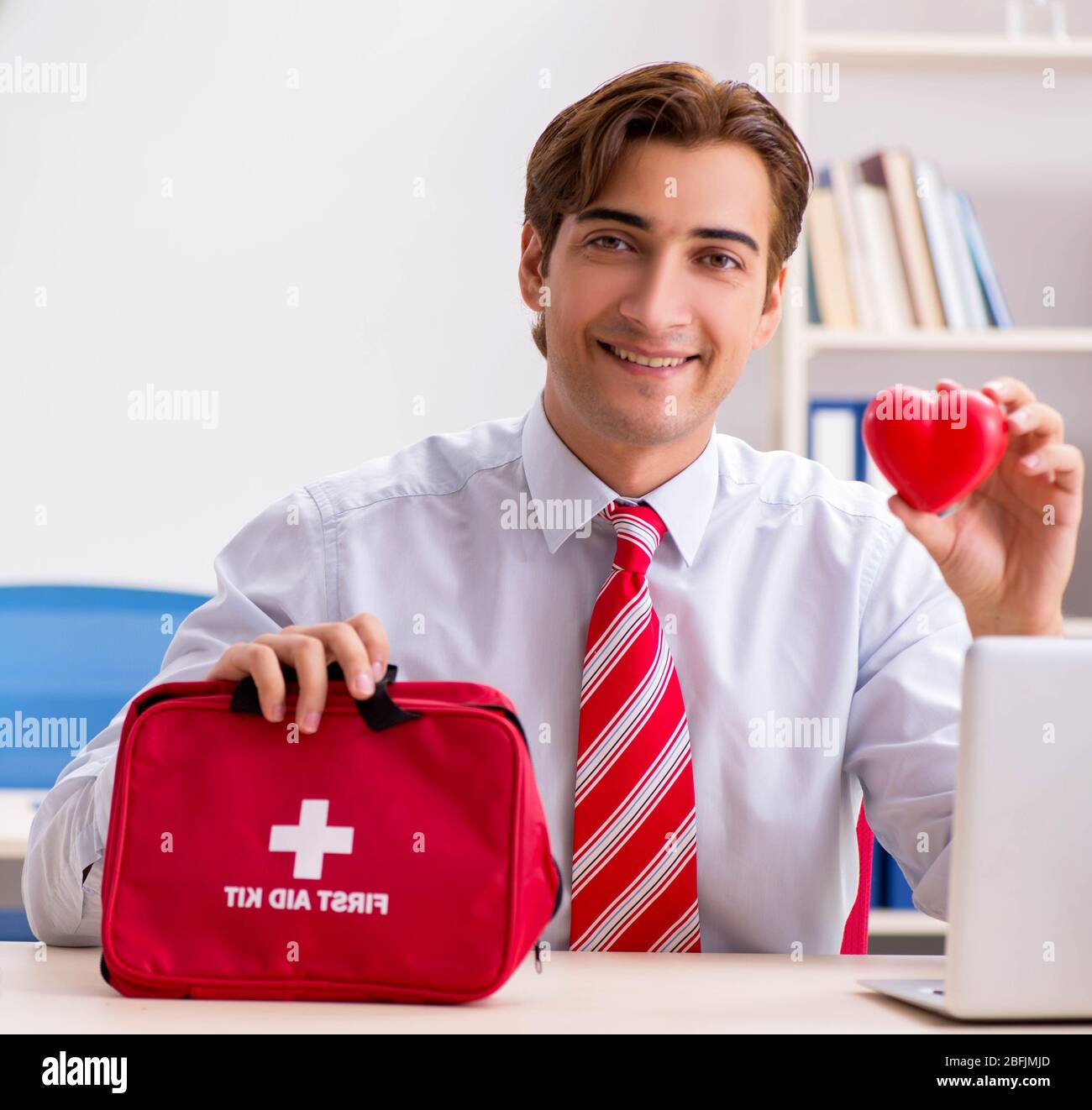 The man with first aid kit in the office Stock Photo - Alamy