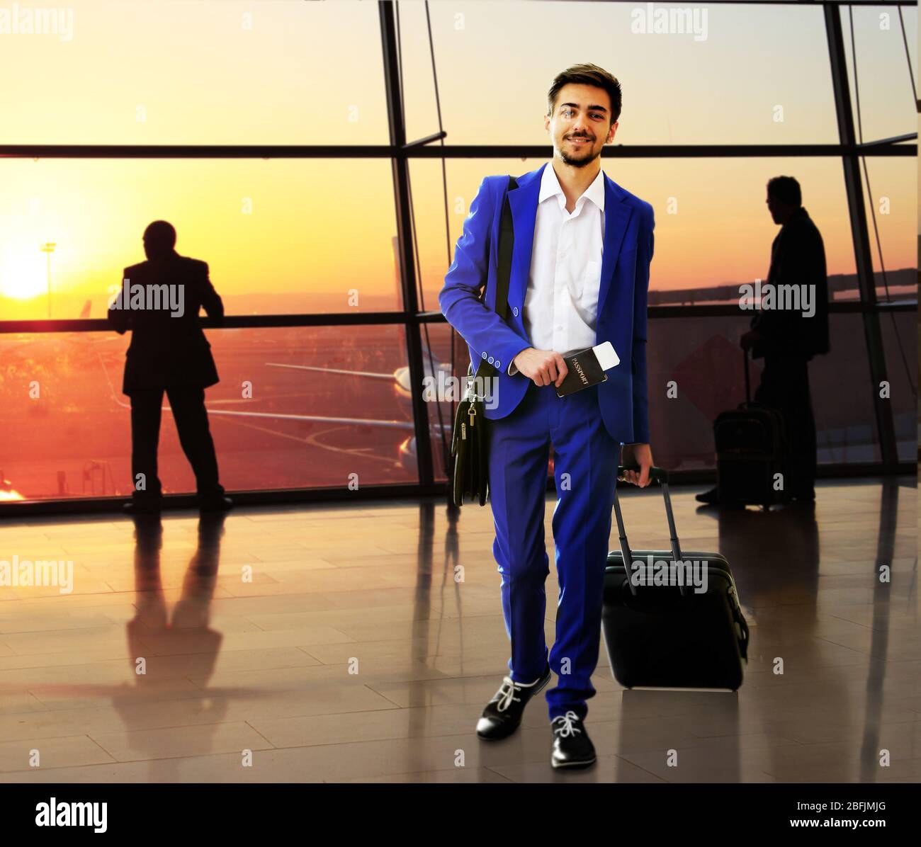 Business man with suitcase in hall of airport Stock Photo - Alamy