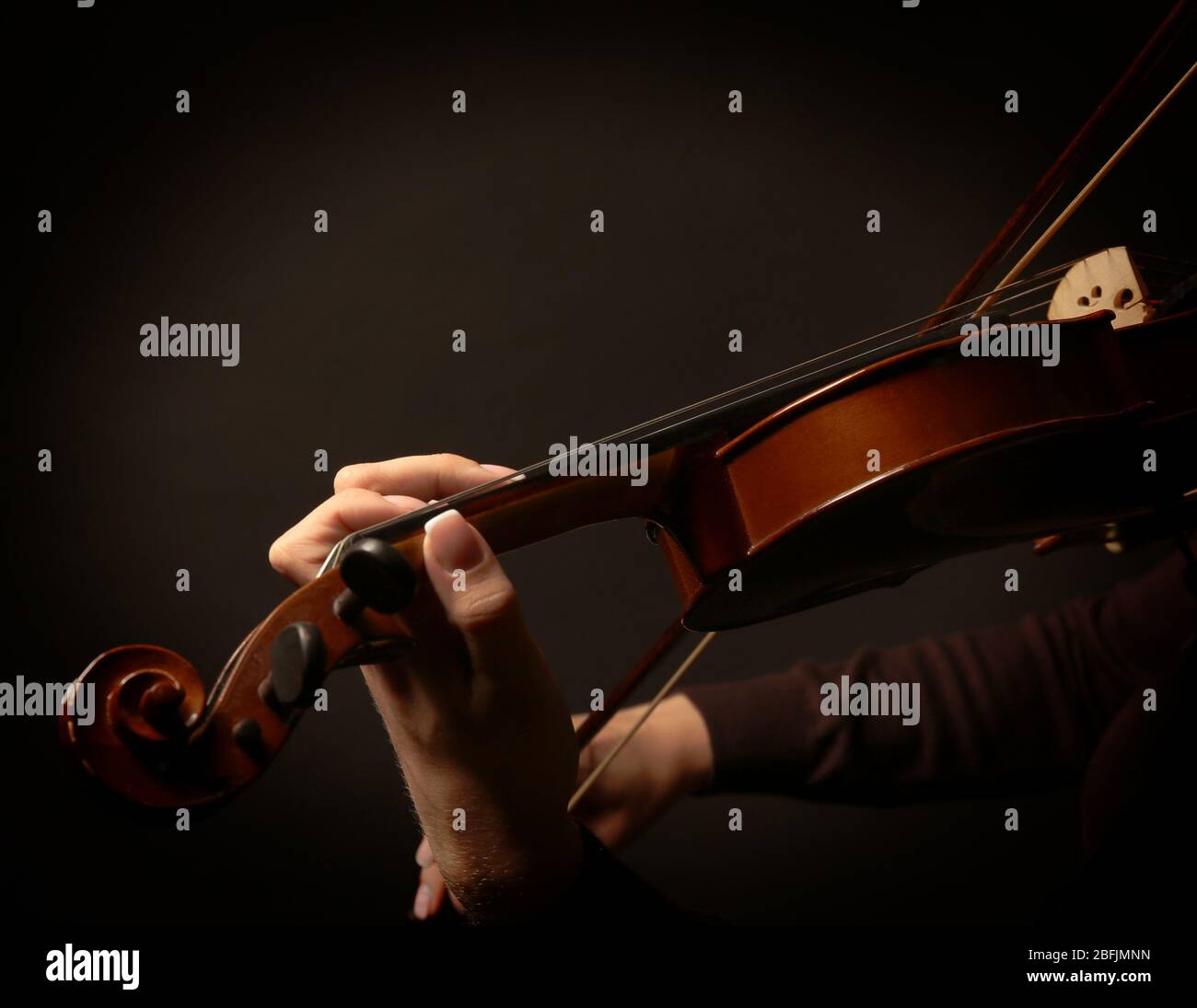 Violinist playing violin on dark background Stock Photo - Alamy