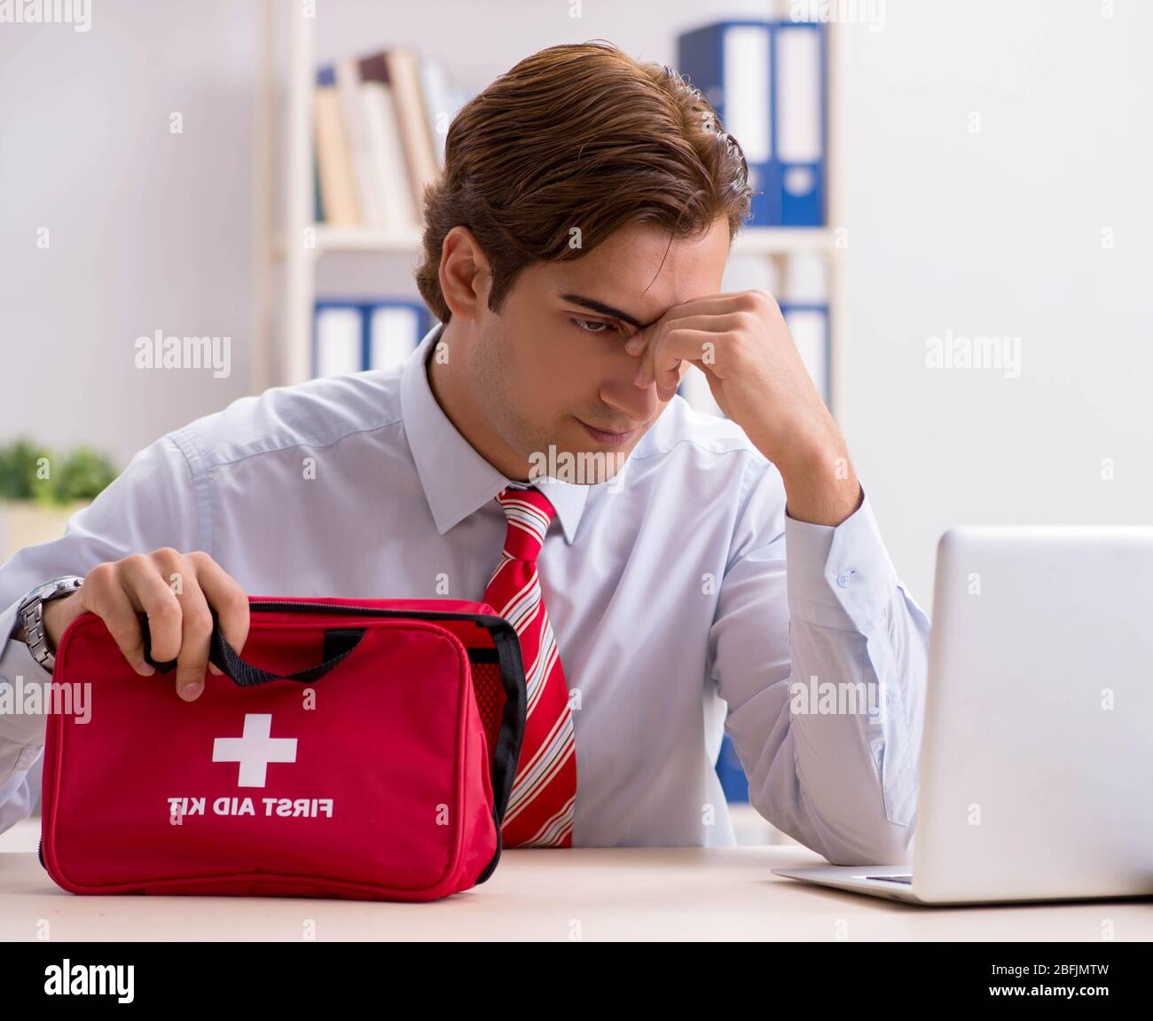 The man with first aid kit in the office Stock Photo - Alamy