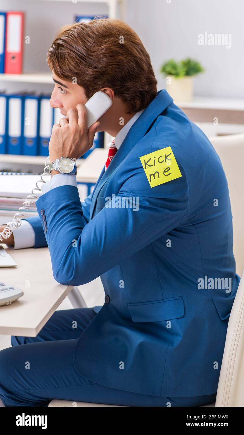 The office prank with kick me message on sticky note Stock Photo - Alamy