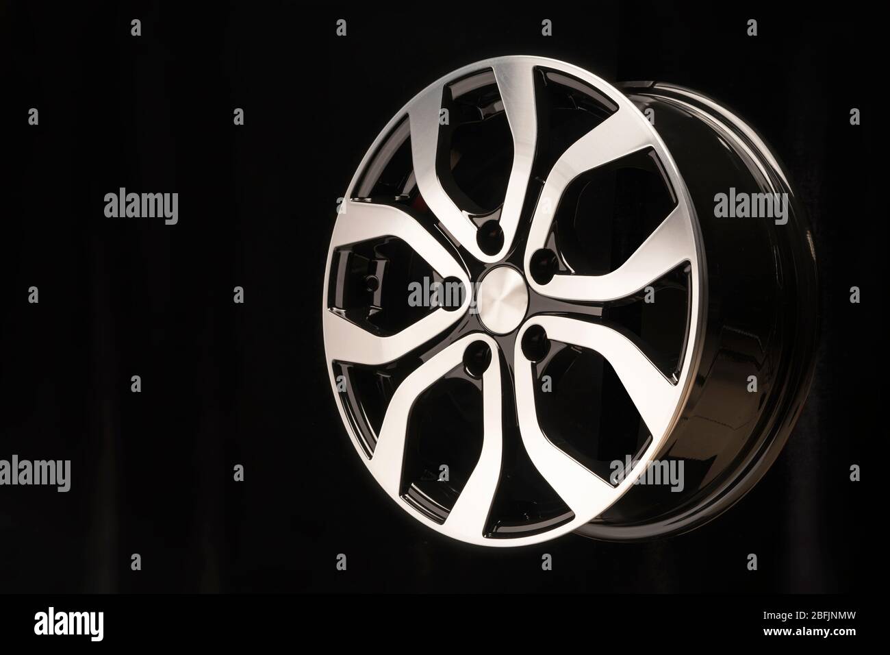 New alloy wheel of the car, close-up on a black background, wheel ...