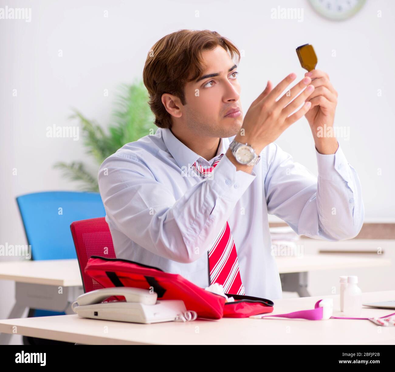 The man with first aid kit in the office Stock Photo - Alamy