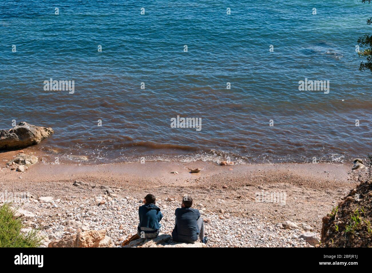 A couple with their backs to the camera and unrecognizable, sitting on ...