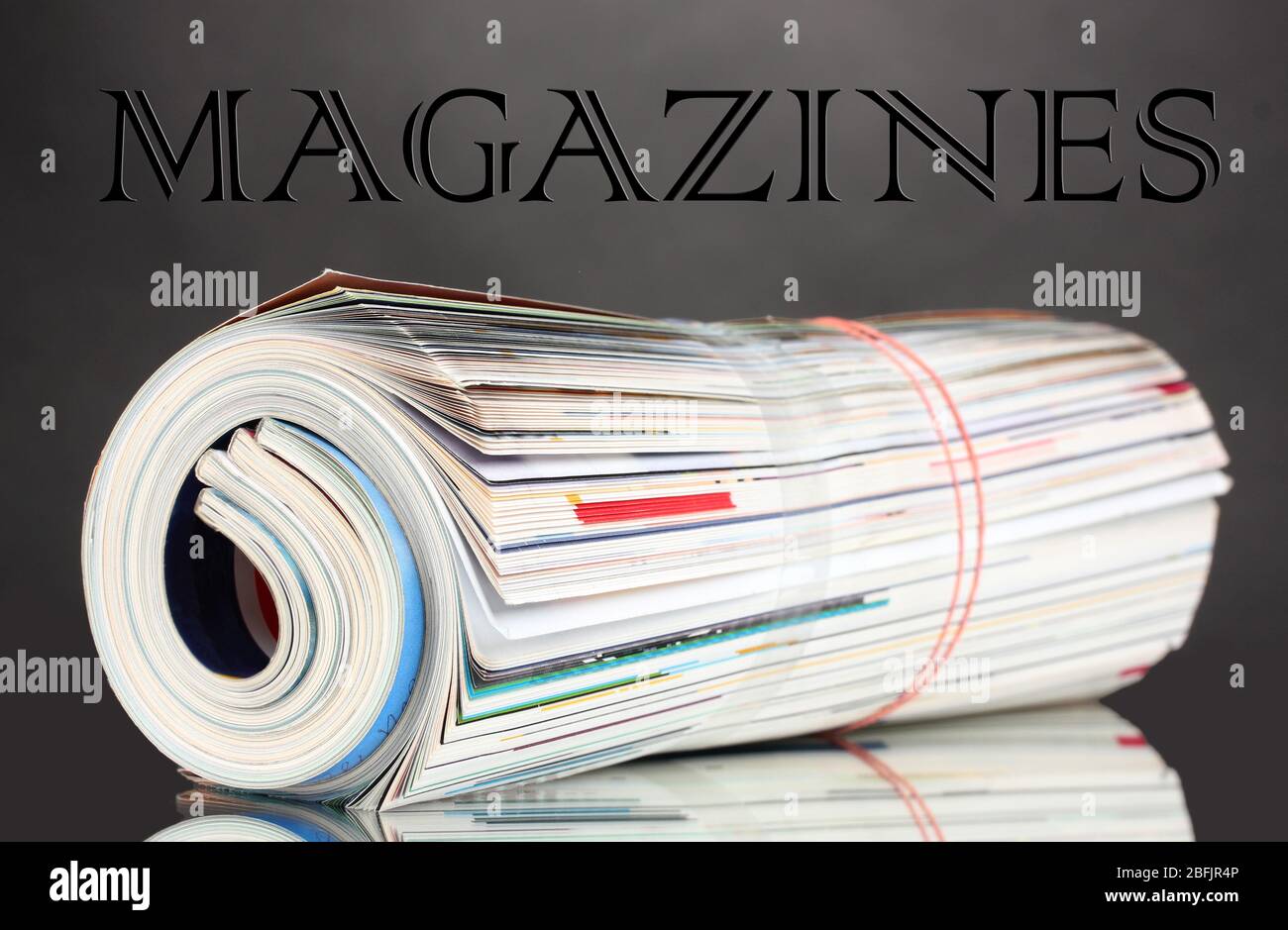 Rolled up magazines on gray background Stock Photo - Alamy