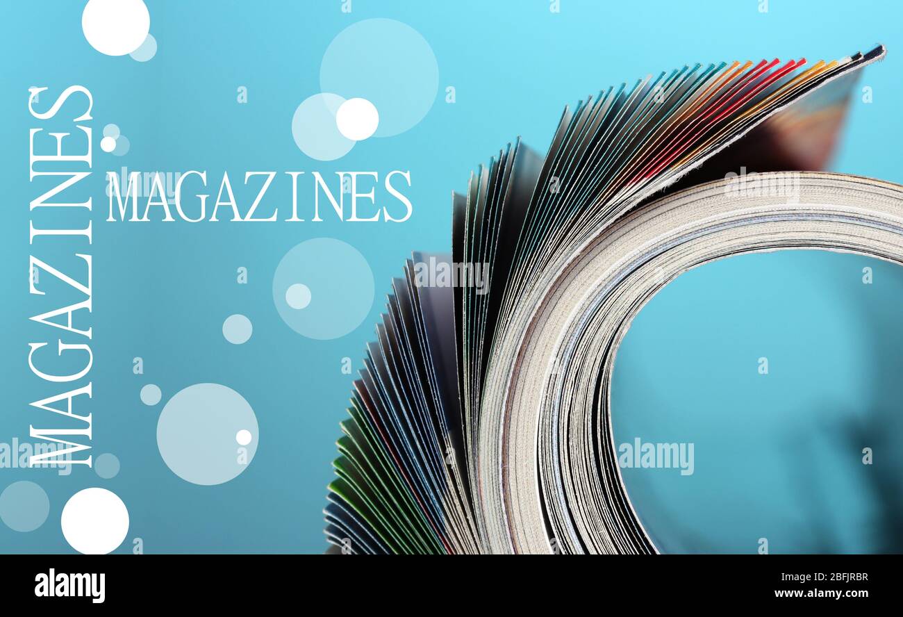 Rolled up magazines on blue background Stock Photo - Alamy