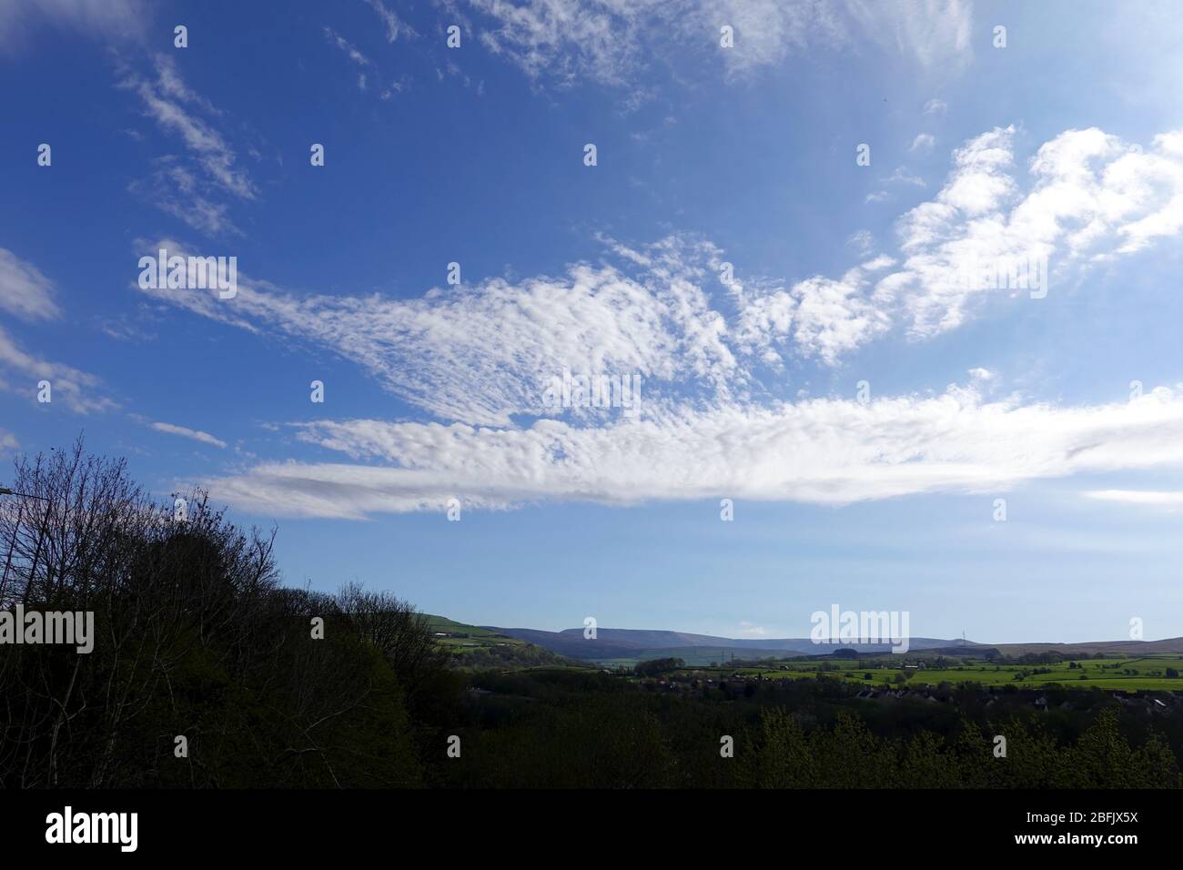 Clouds in a blue sky over New Mills, Derbyshire Stock Photo - Alamy