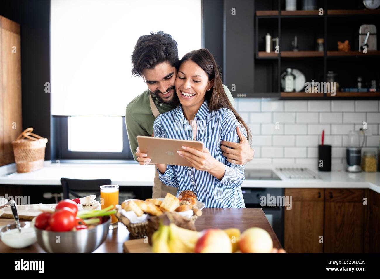 Beautiful couple in the kitchen while cooking Stock Photo - Alamy