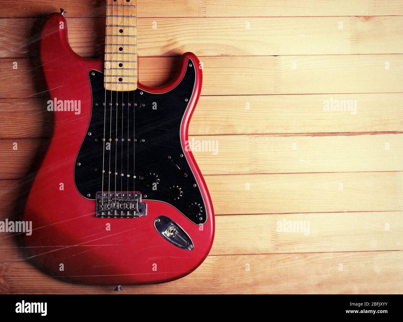 Red guitar on wooden background Stock Photo - Alamy