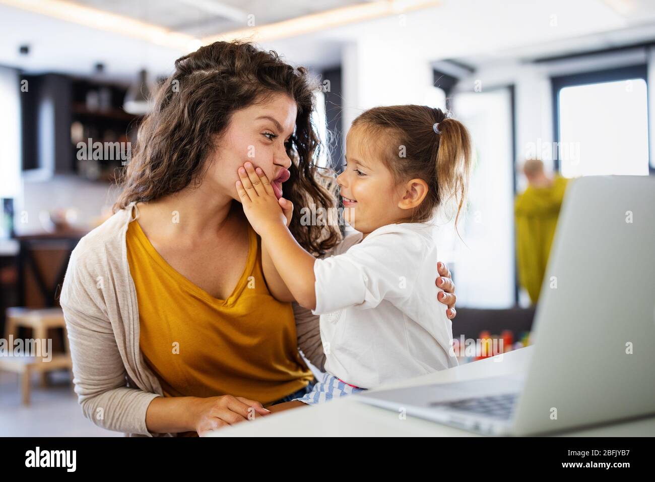 Mother at home trying to work with child distracting her Stock Photo ...