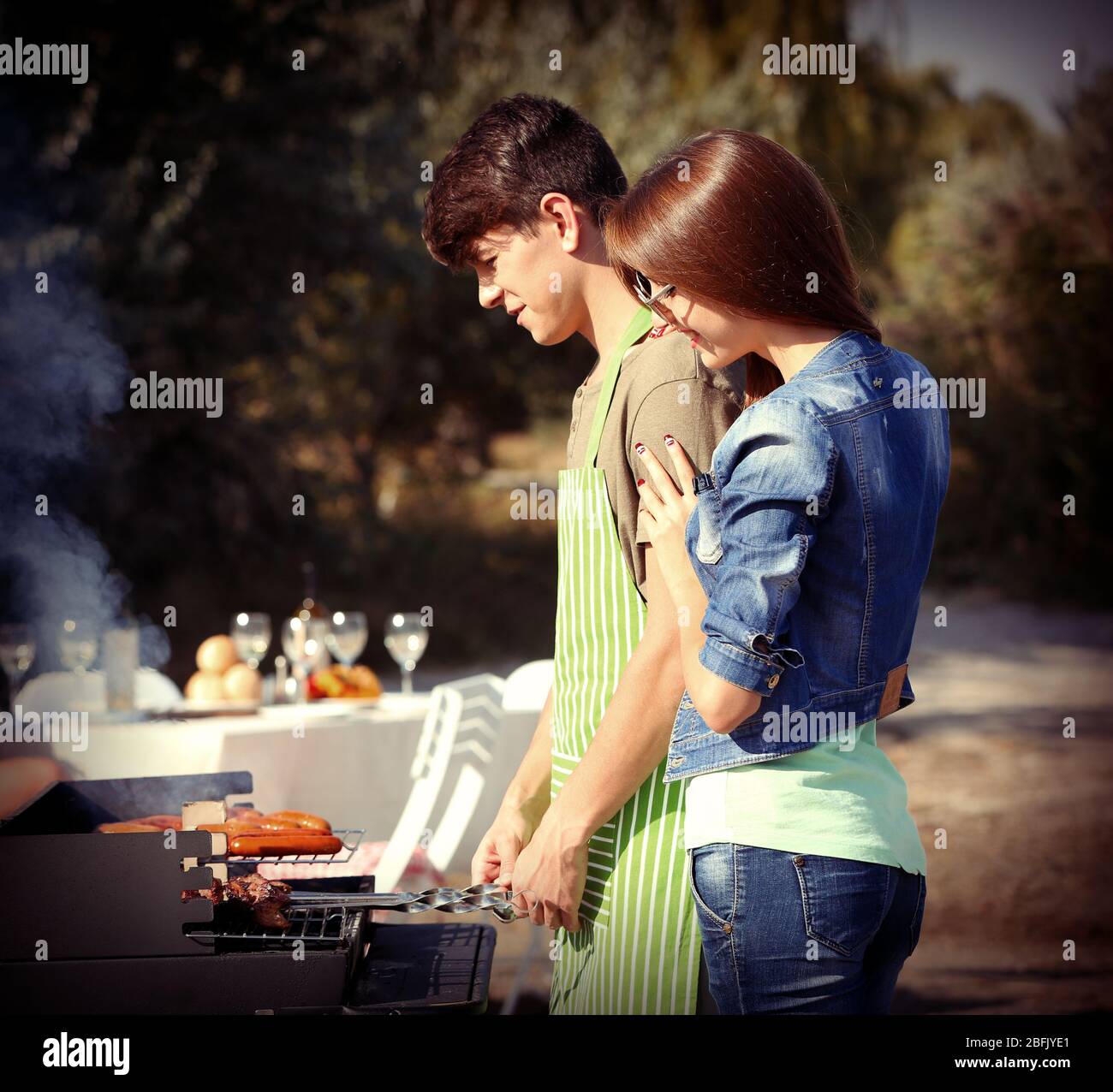 Beautiful couple having barbecue party, outdoors Stock Photo - Alamy