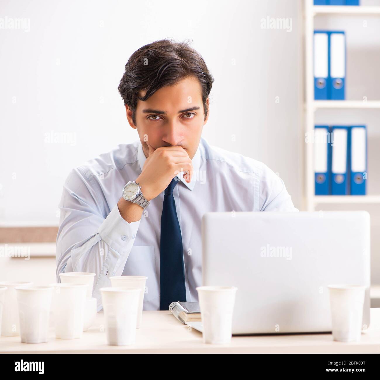 The young employee addicted to coffee Stock Photo - Alamy