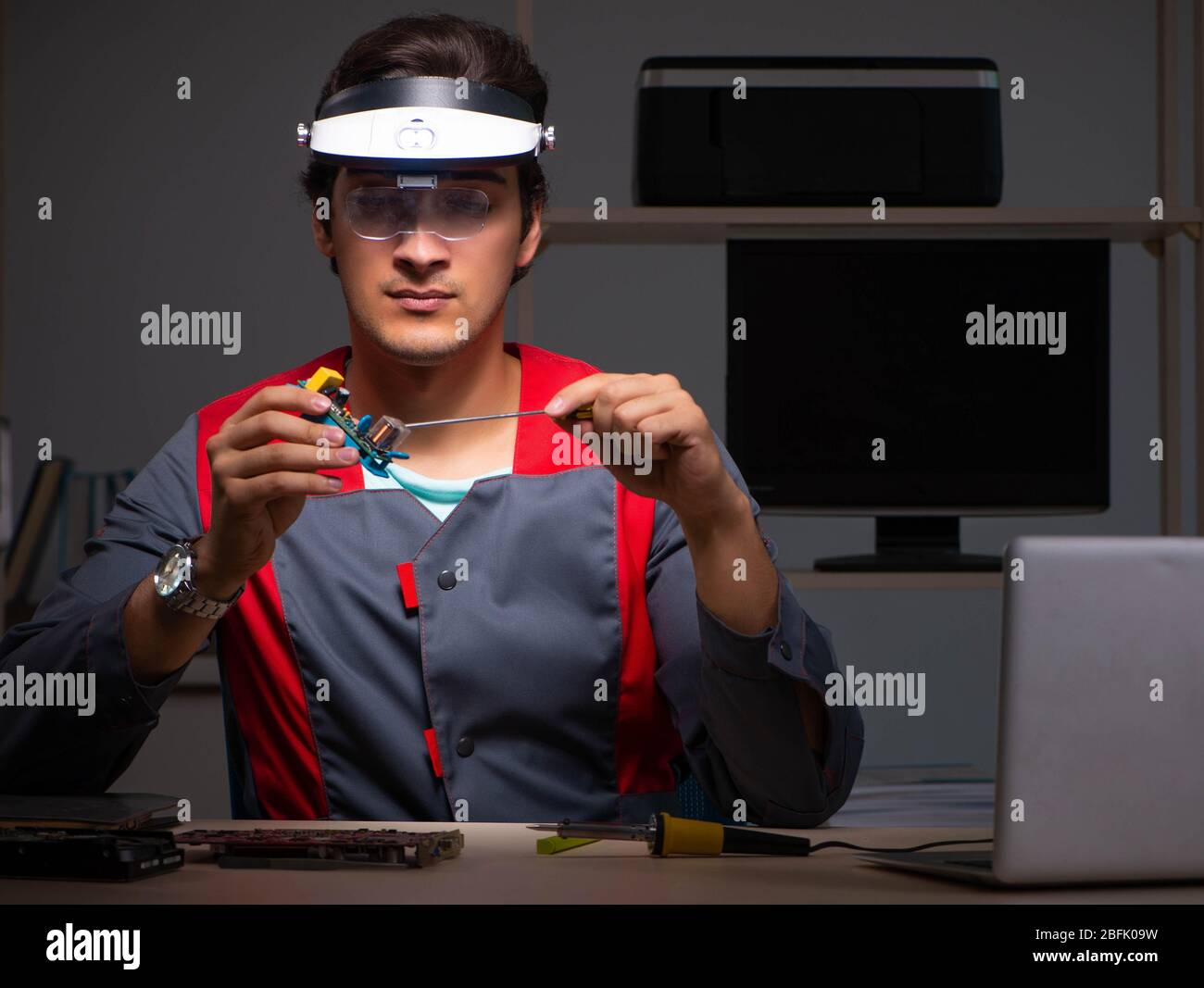 The young handsome repairman repairing computer Stock Photo - Alamy
