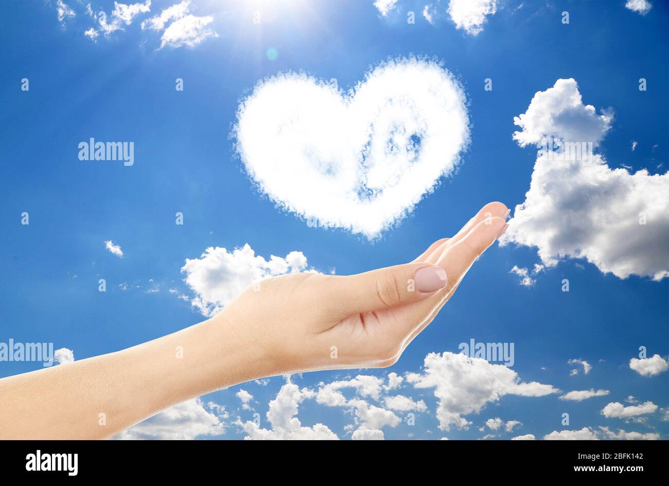 Heart clouds shape floating on hand Stock Photo - Alamy