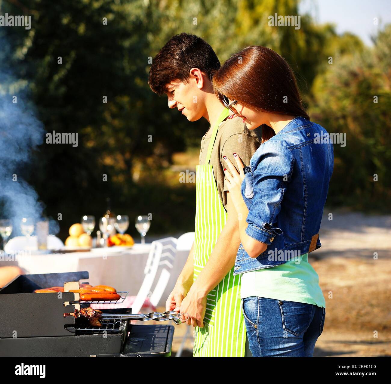 Beautiful couple having barbecue party, outdoors Stock Photo - Alamy