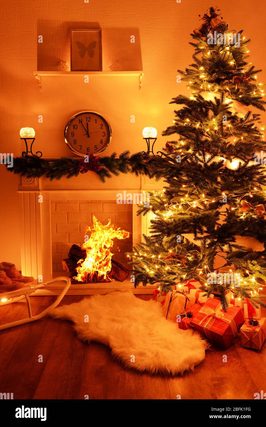 Christmas tree near fireplace in room Stock Photo - Alamy