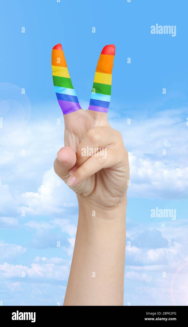Man's hand with fingers painted as the rainbow flag isolated on white ...