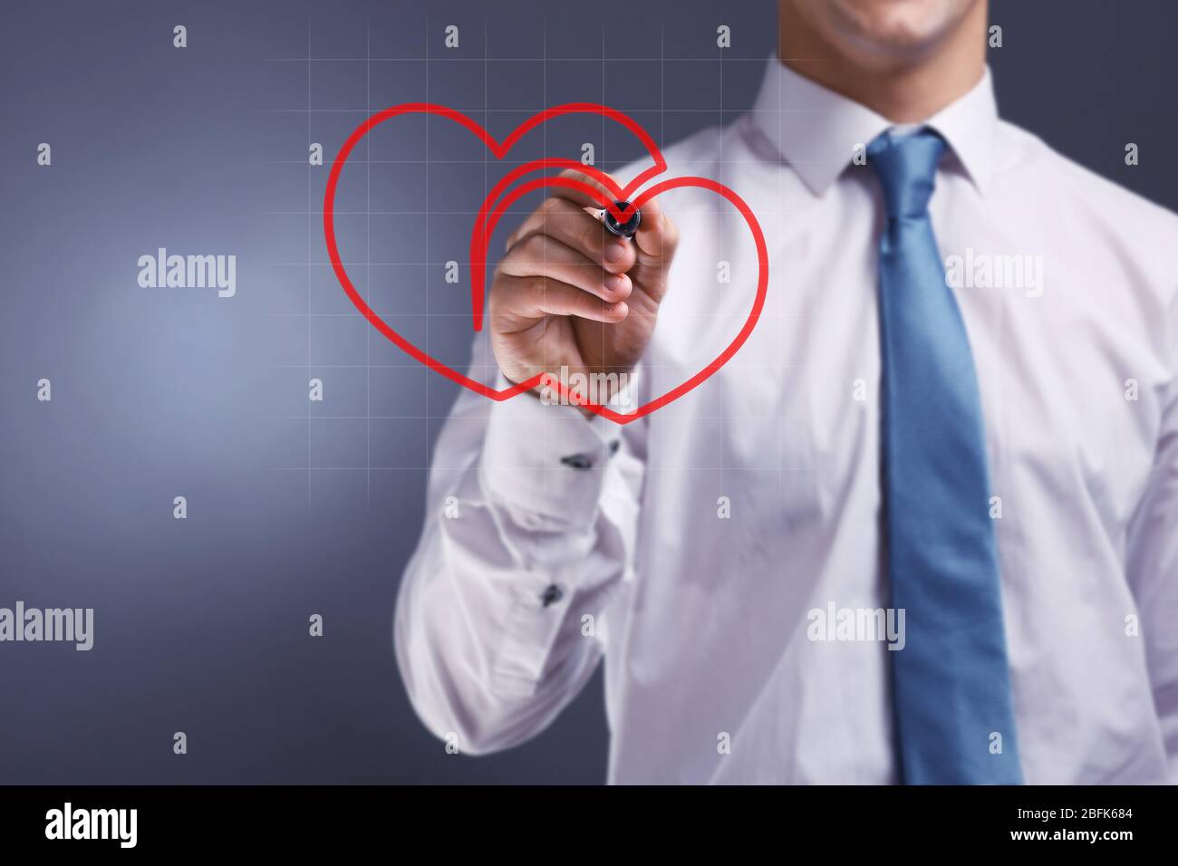 Man drawing heart on grey background Stock Photo - Alamy