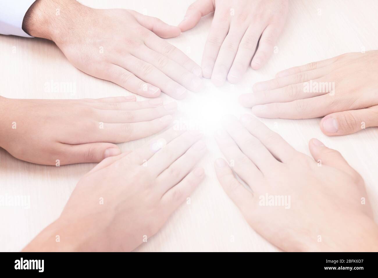 Many hands with light Stock Photo - Alamy