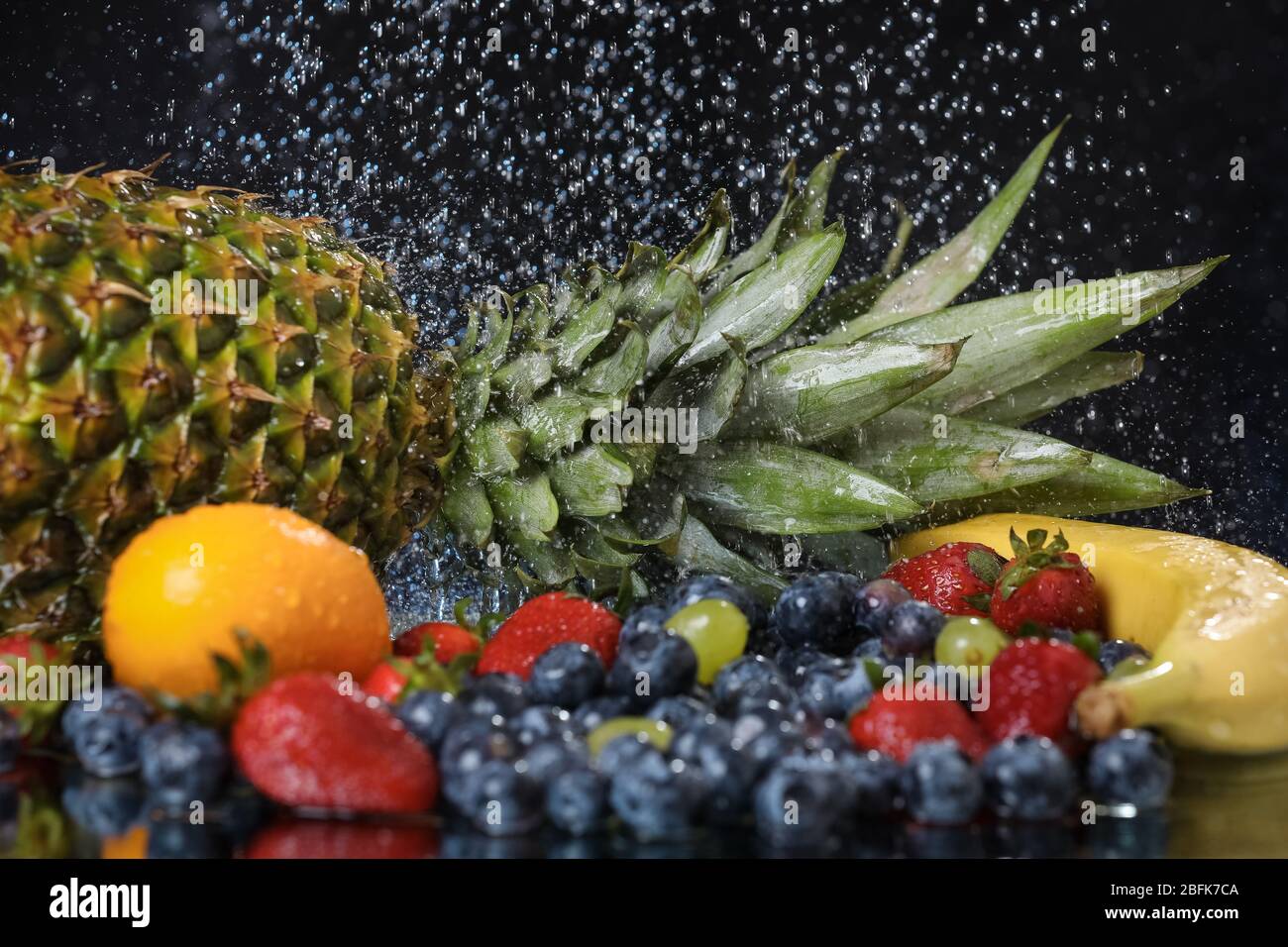 Tropical fruits close up on a table. strawberry, grape, blueberry ...