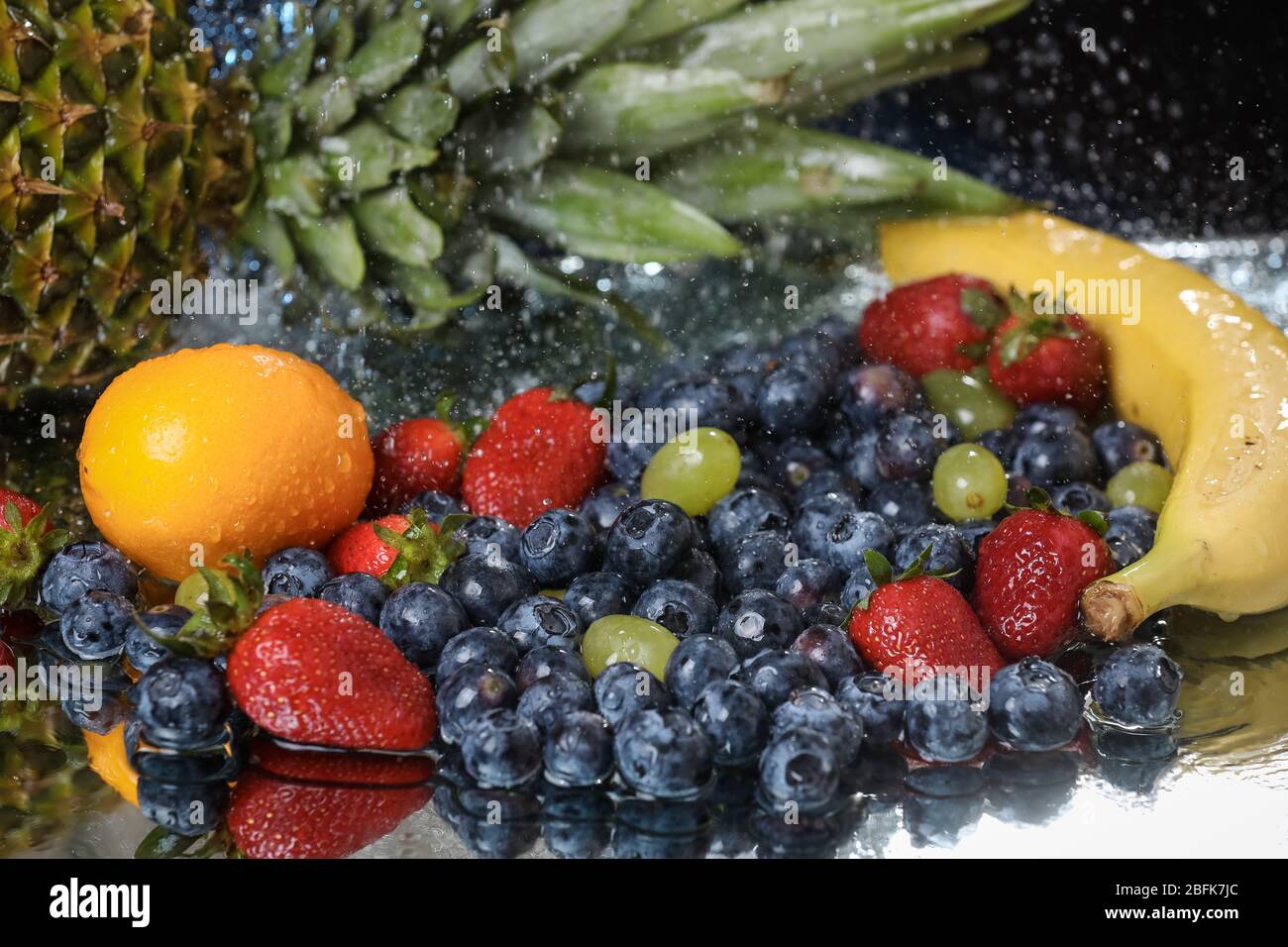 Tropical fruits close up on a table. strawberry, grape, blueberry ...