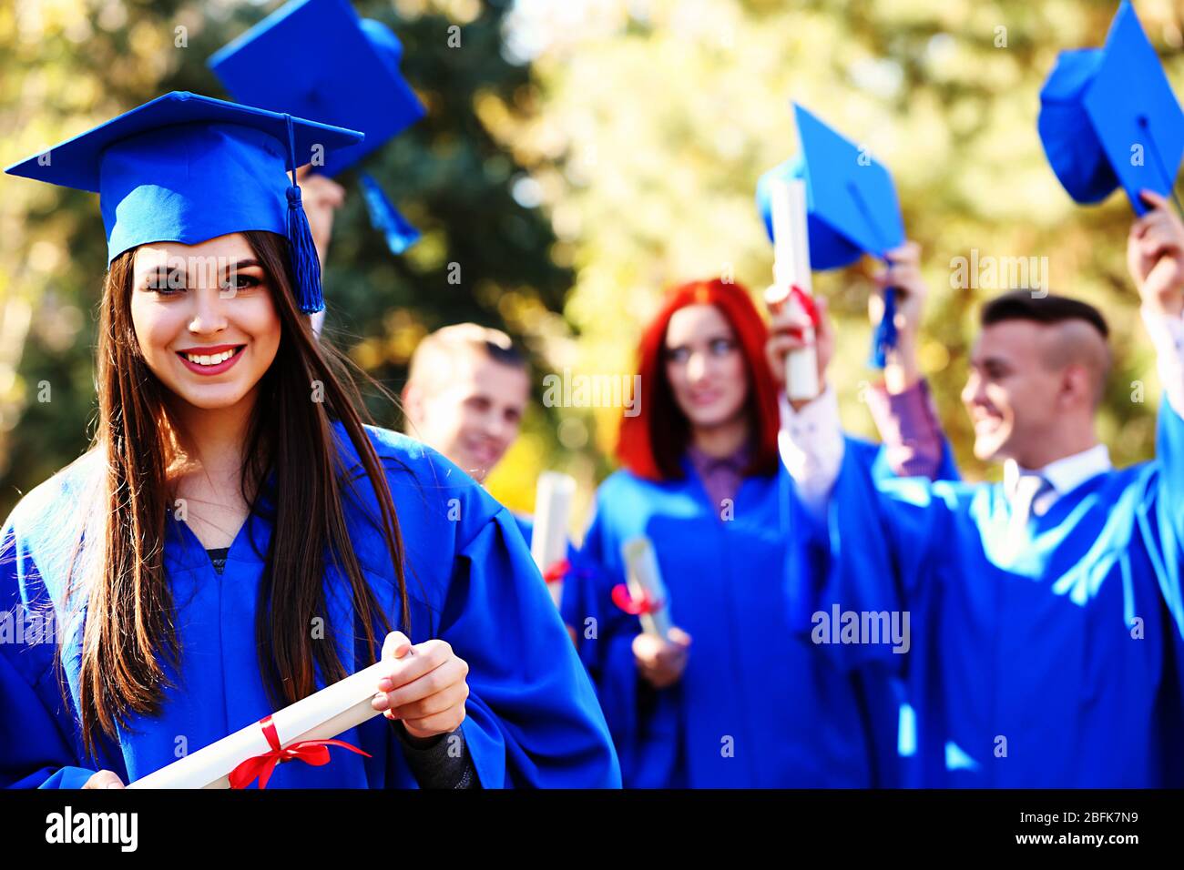 Graduated students in graduation hats and gowns, outdoors Stock Photo ...