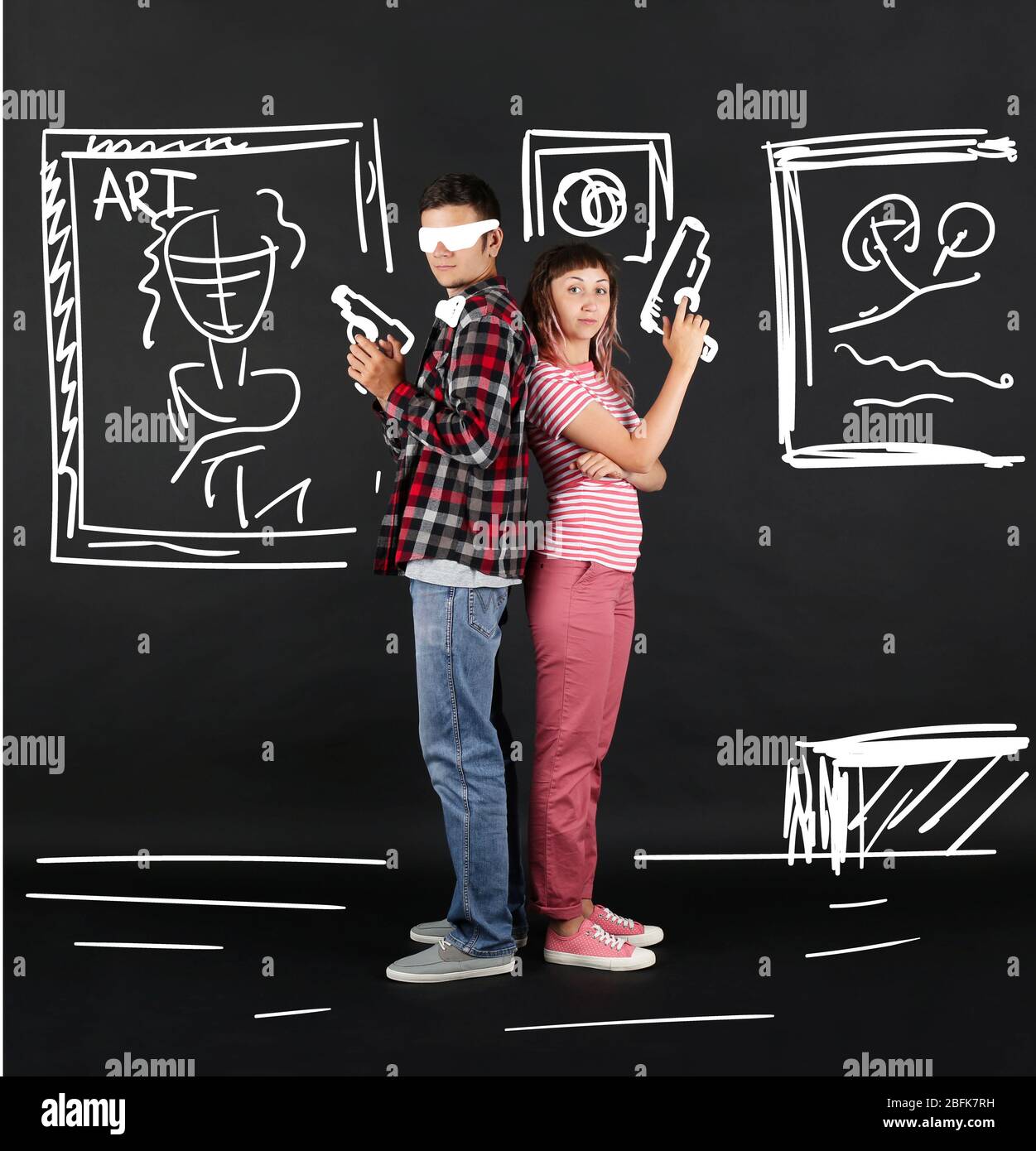 Funny young couple as a spy agents, on black background Stock Photo - Alamy