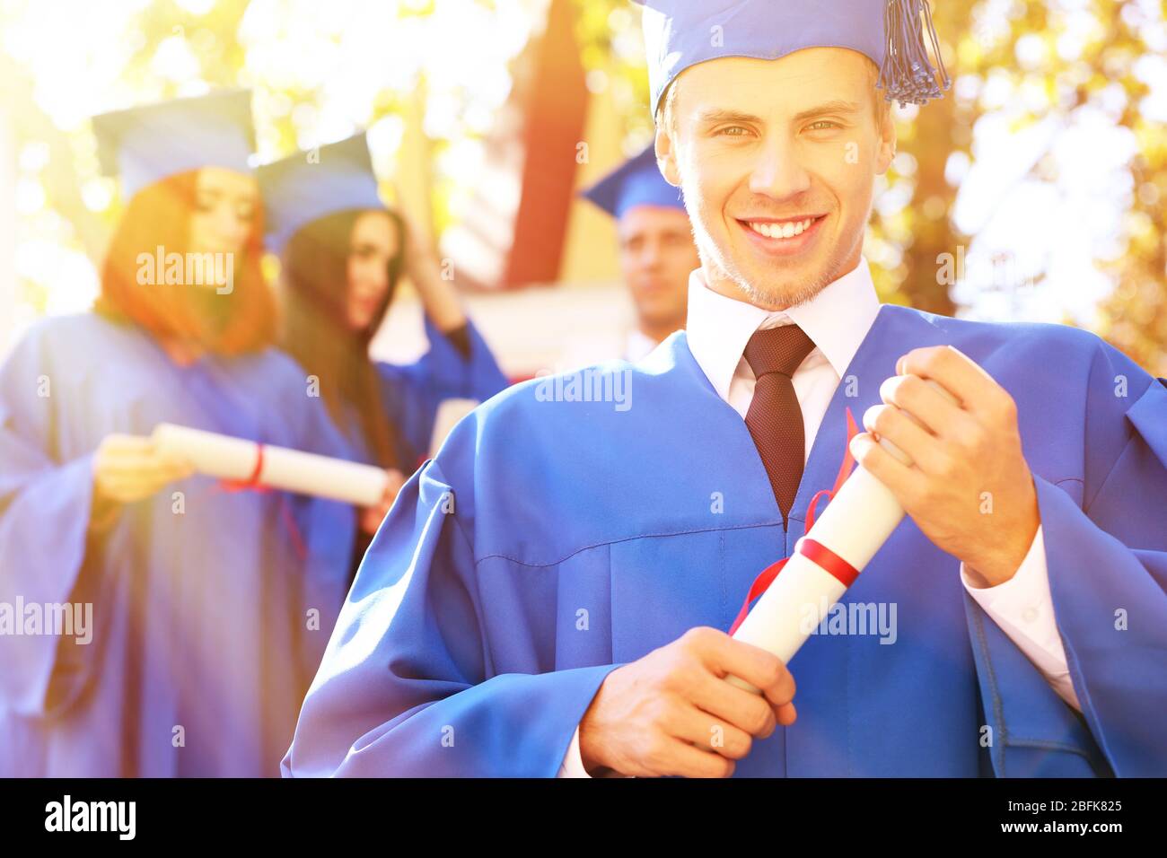 Graduated students in graduation hat and gown, outdoors Stock Photo - Alamy