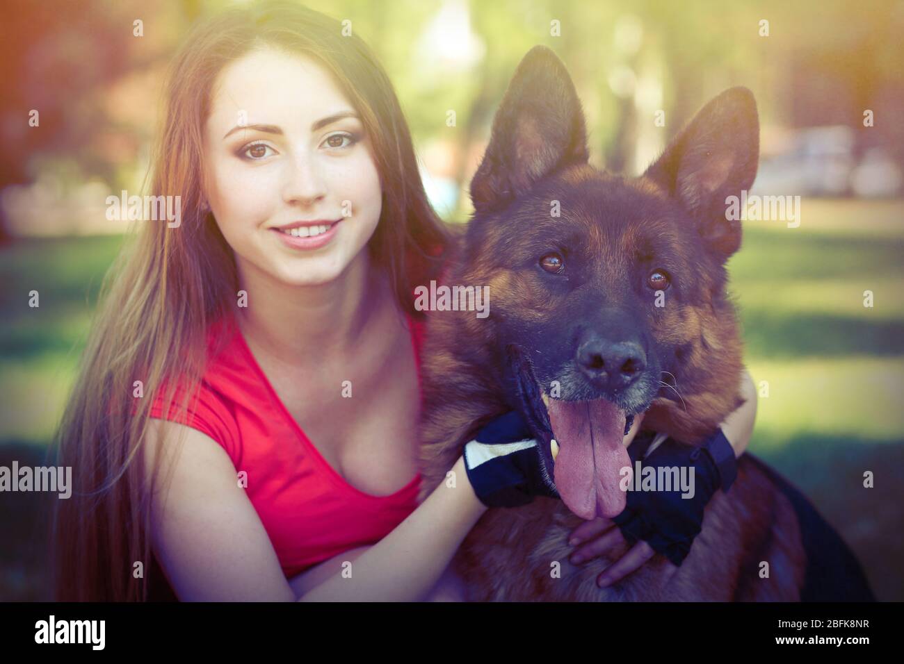 Beautiful young girl with dog in park Stock Photo - Alamy