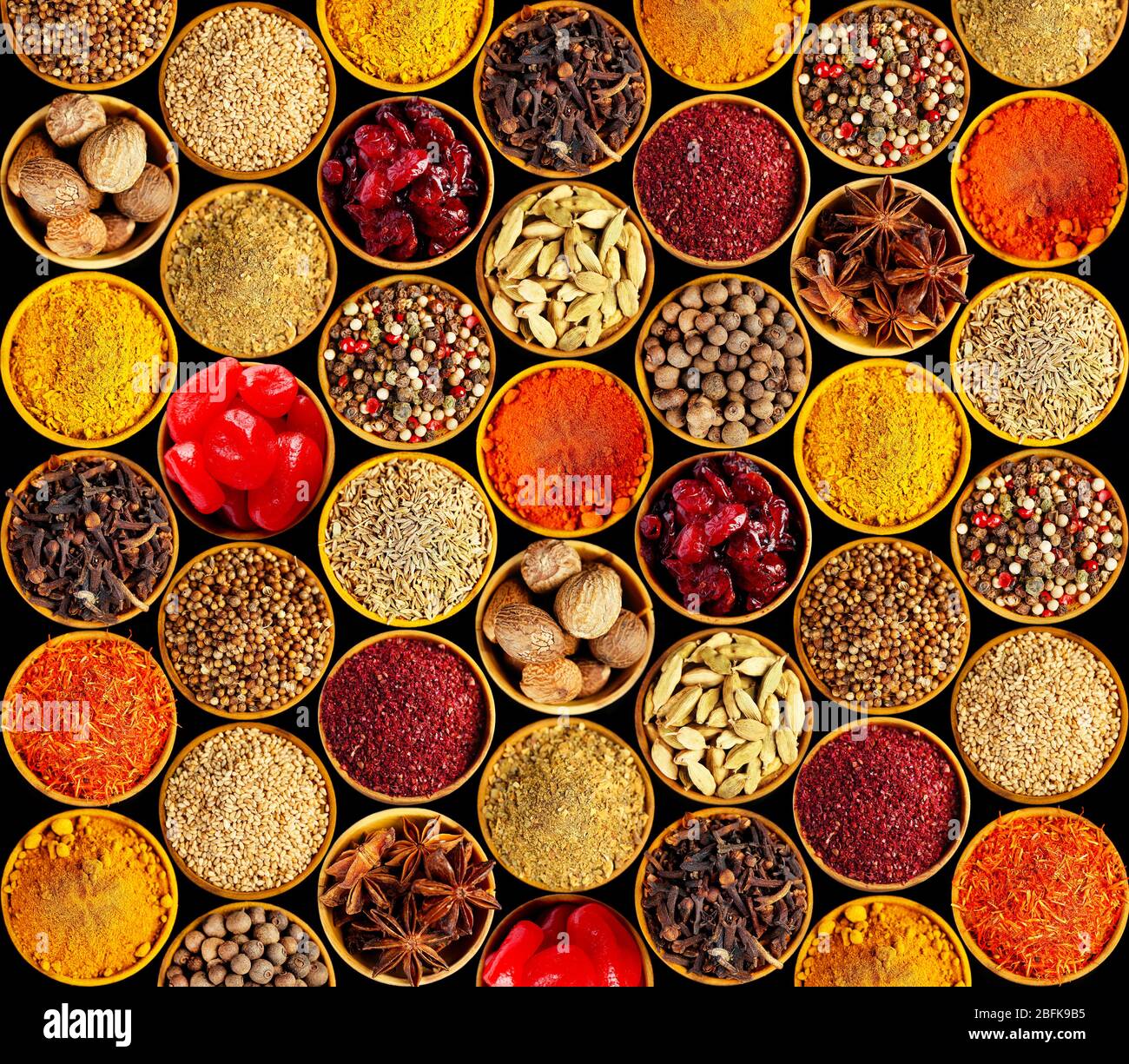 Different spices on black background Stock Photo - Alamy