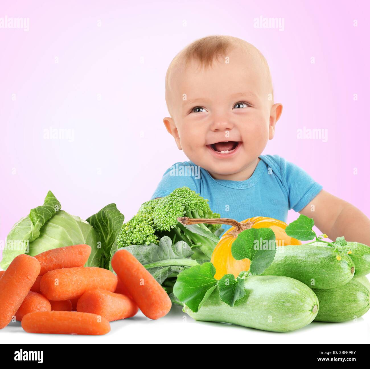Cute baby and vegetable mix on light pink background Stock Photo - Alamy