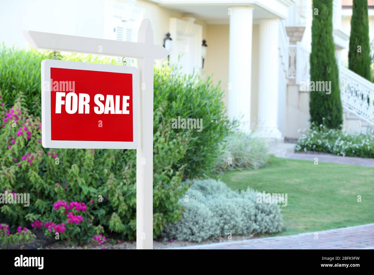 Real estate sign in front of new house for sale Stock Photo - Alamy