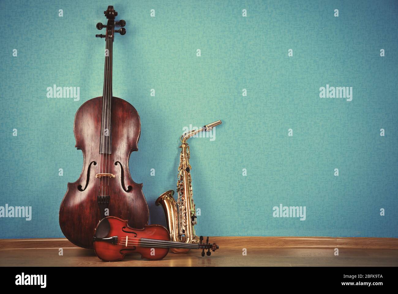 Musical instruments on turquoise wallpaper background Stock Photo - Alamy