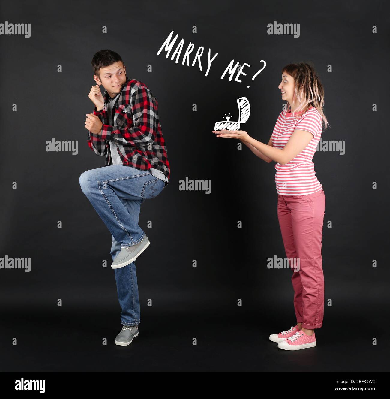 Romantic woman proposing to a man, on black background Stock Photo - Alamy