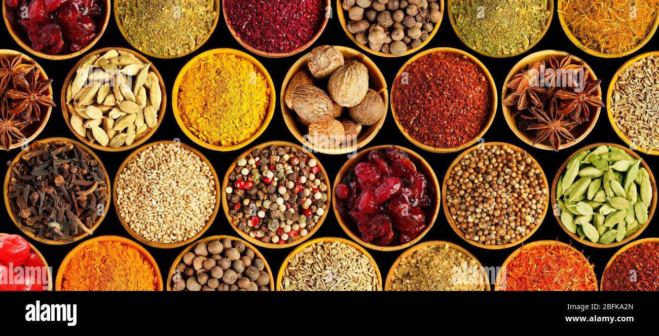 Different spices on black background Stock Photo - Alamy