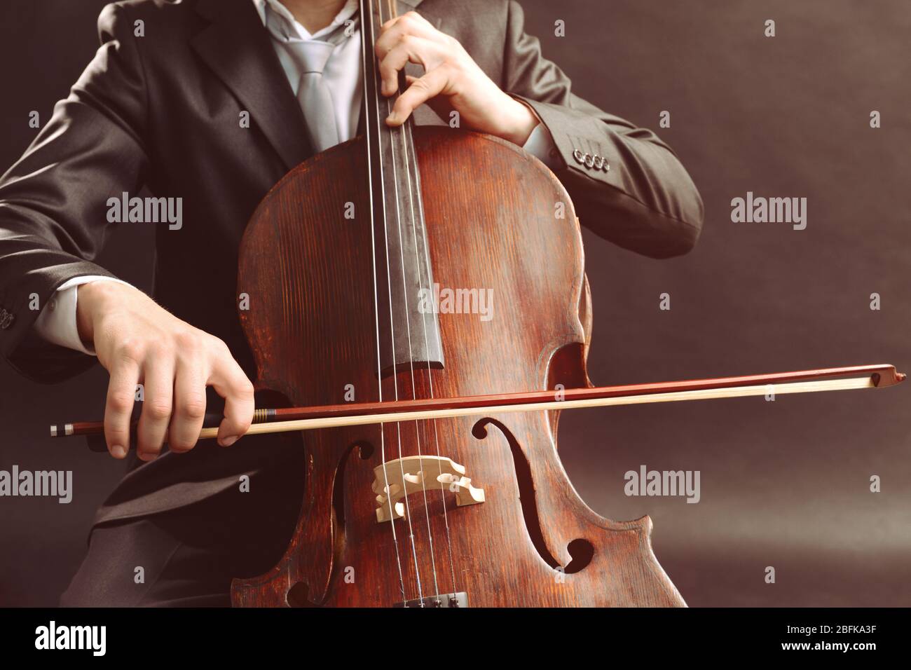 Man playing on cello on dark background Stock Photo - Alamy