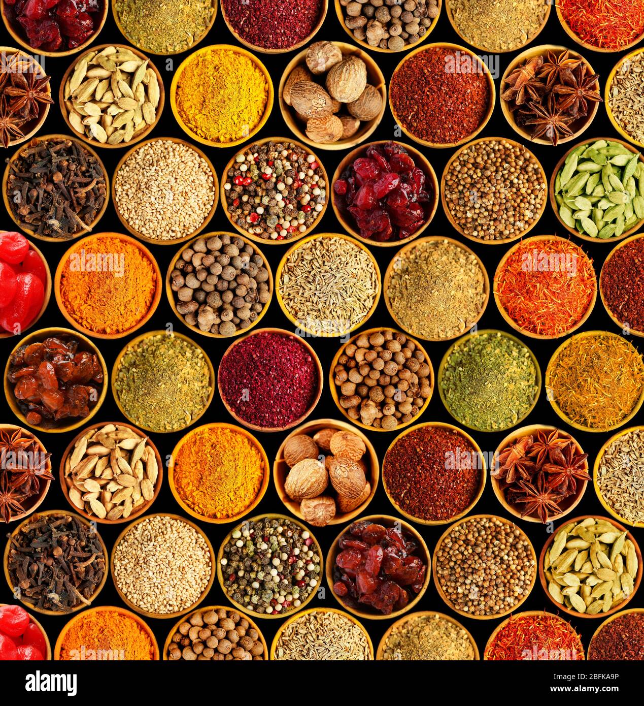 Different spices on black background Stock Photo - Alamy