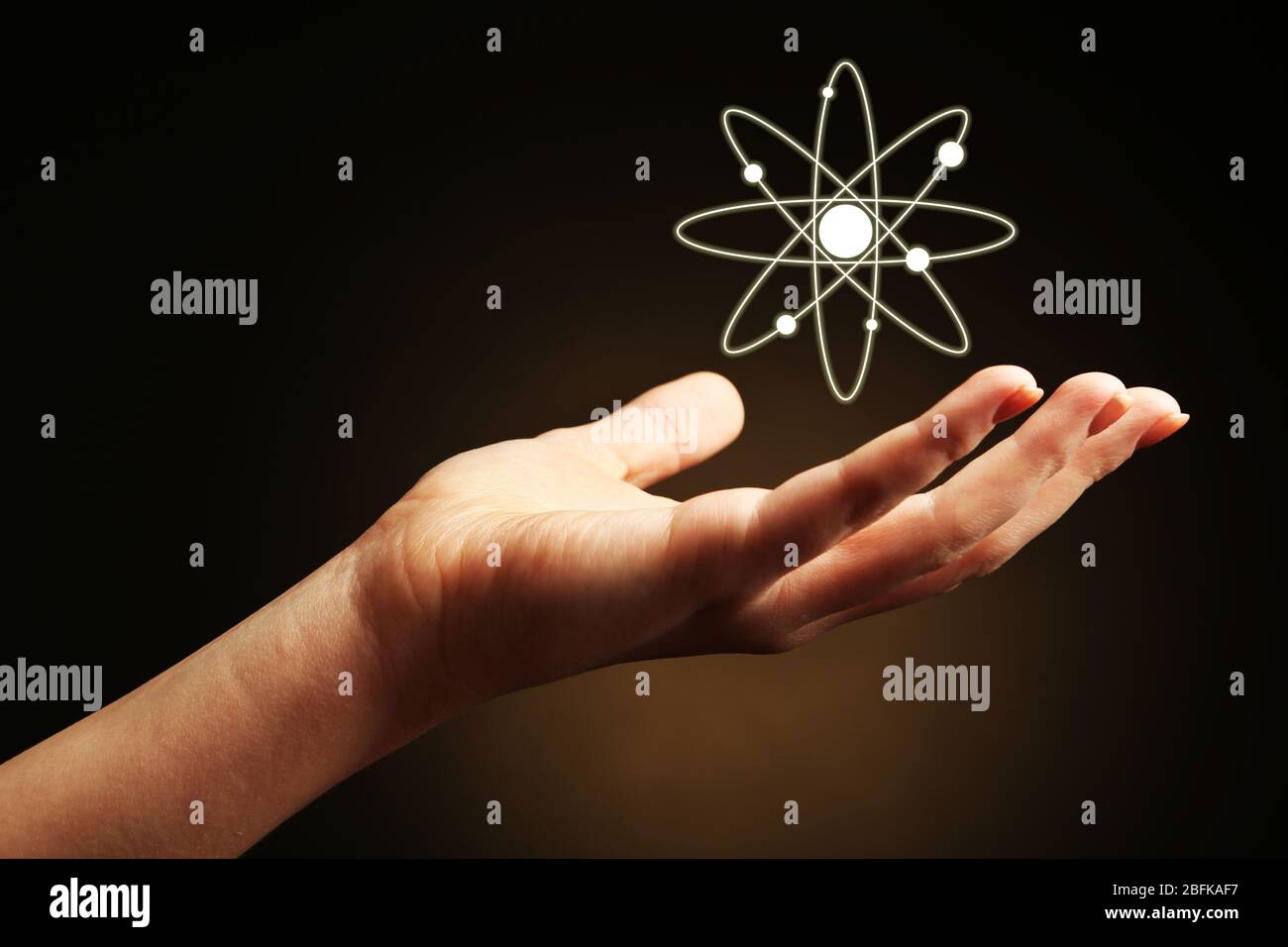 Hand with atom image, on black background Stock Photo - Alamy