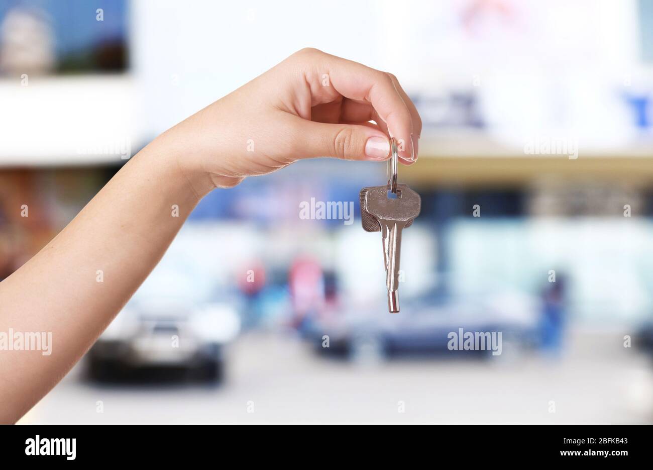 Keys in hand on blurred background store Stock Photo - Alamy