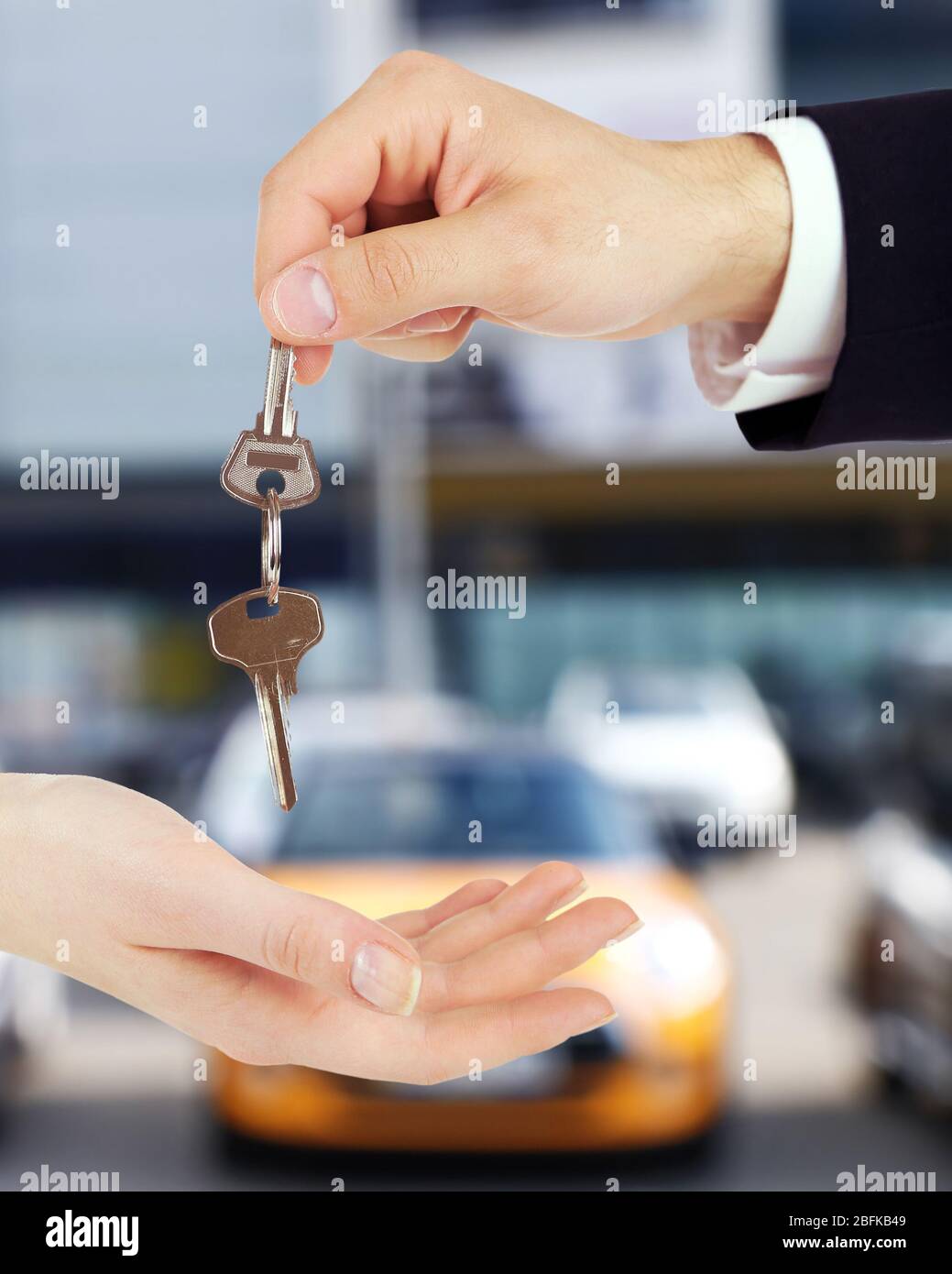 Keys in hand on blurred background store Stock Photo - Alamy