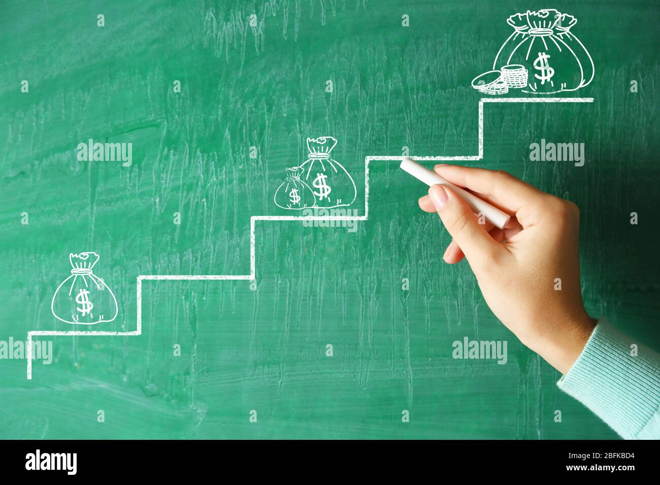 Money concept.Female hand drawing on blackboard Stock Photo - Alamy