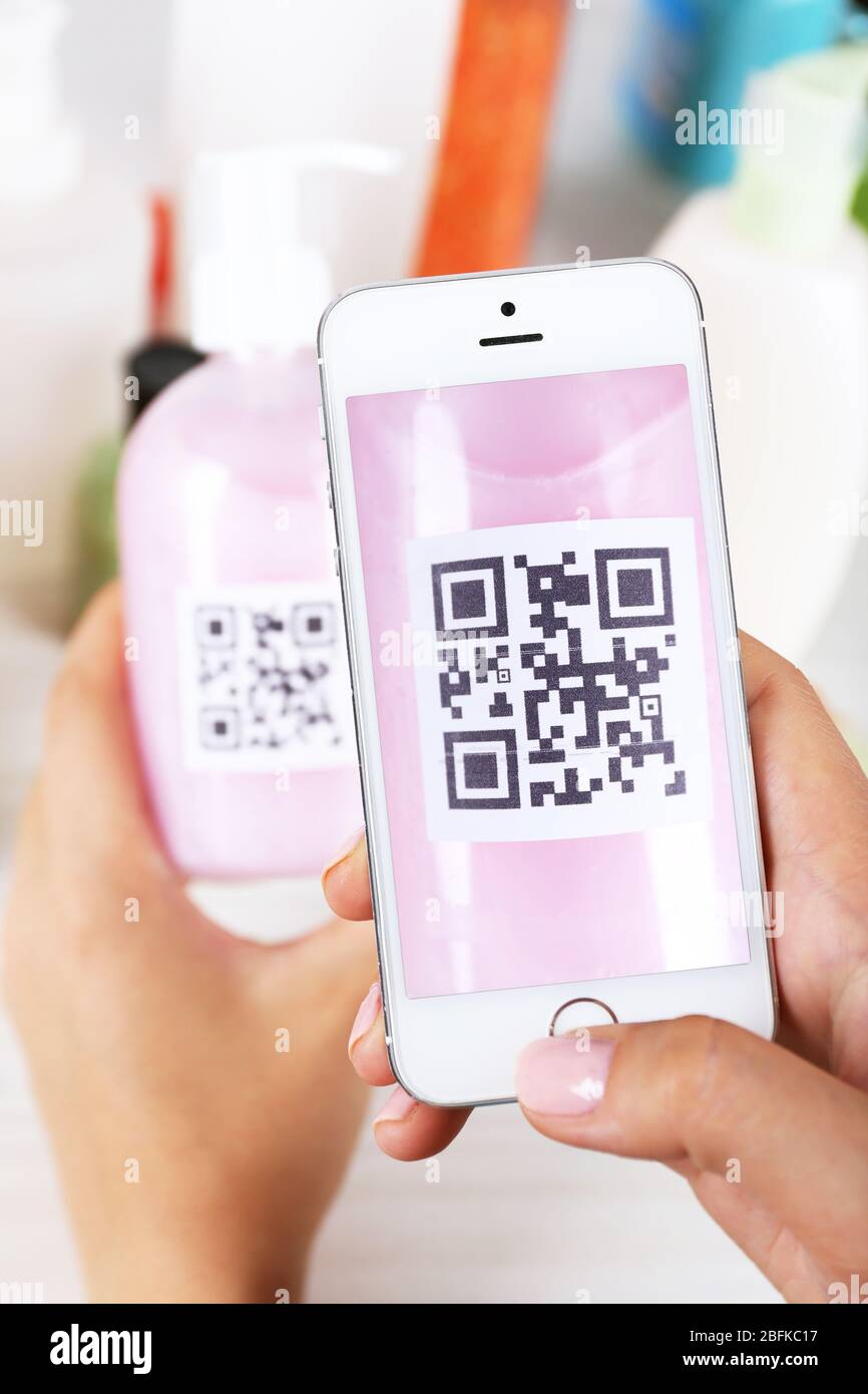 Woman scanning voucher code with mobile phone close up Stock Photo - Alamy