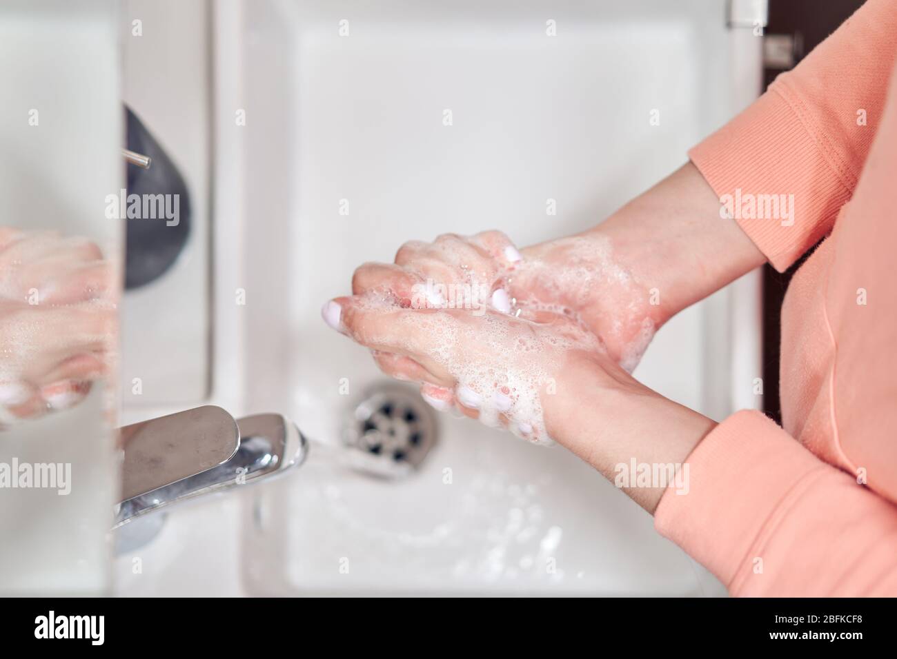 Woman washing hands over the sink in bath. Top view Stock Photo - Alamy
