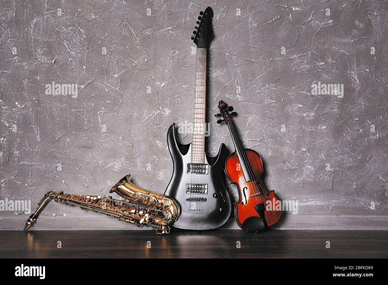 Electric guitar, saxophone and violin on gray wall background Stock ...