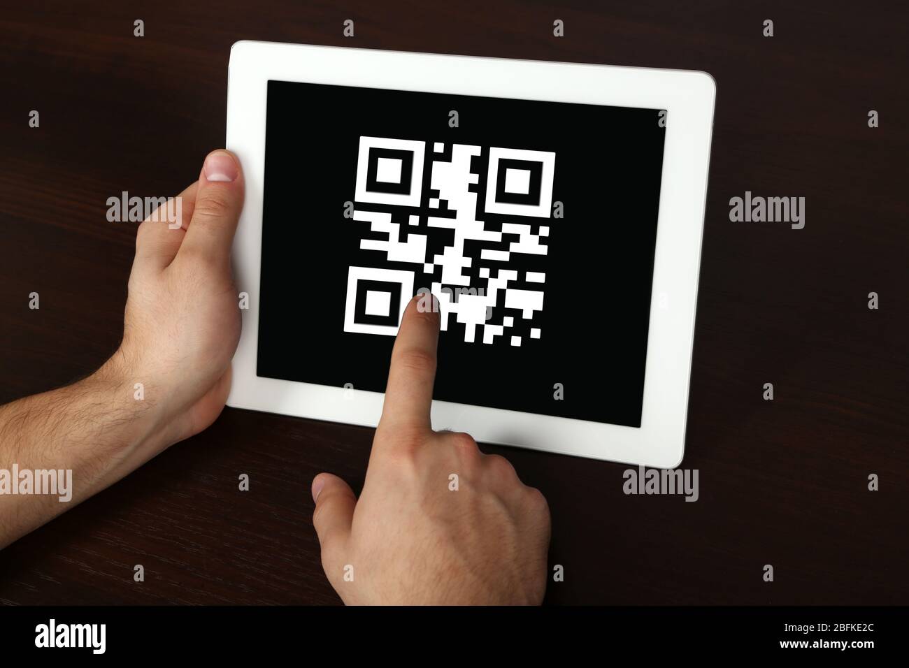 Hands holding tablet PC with QR code on screen Stock Photo - Alamy