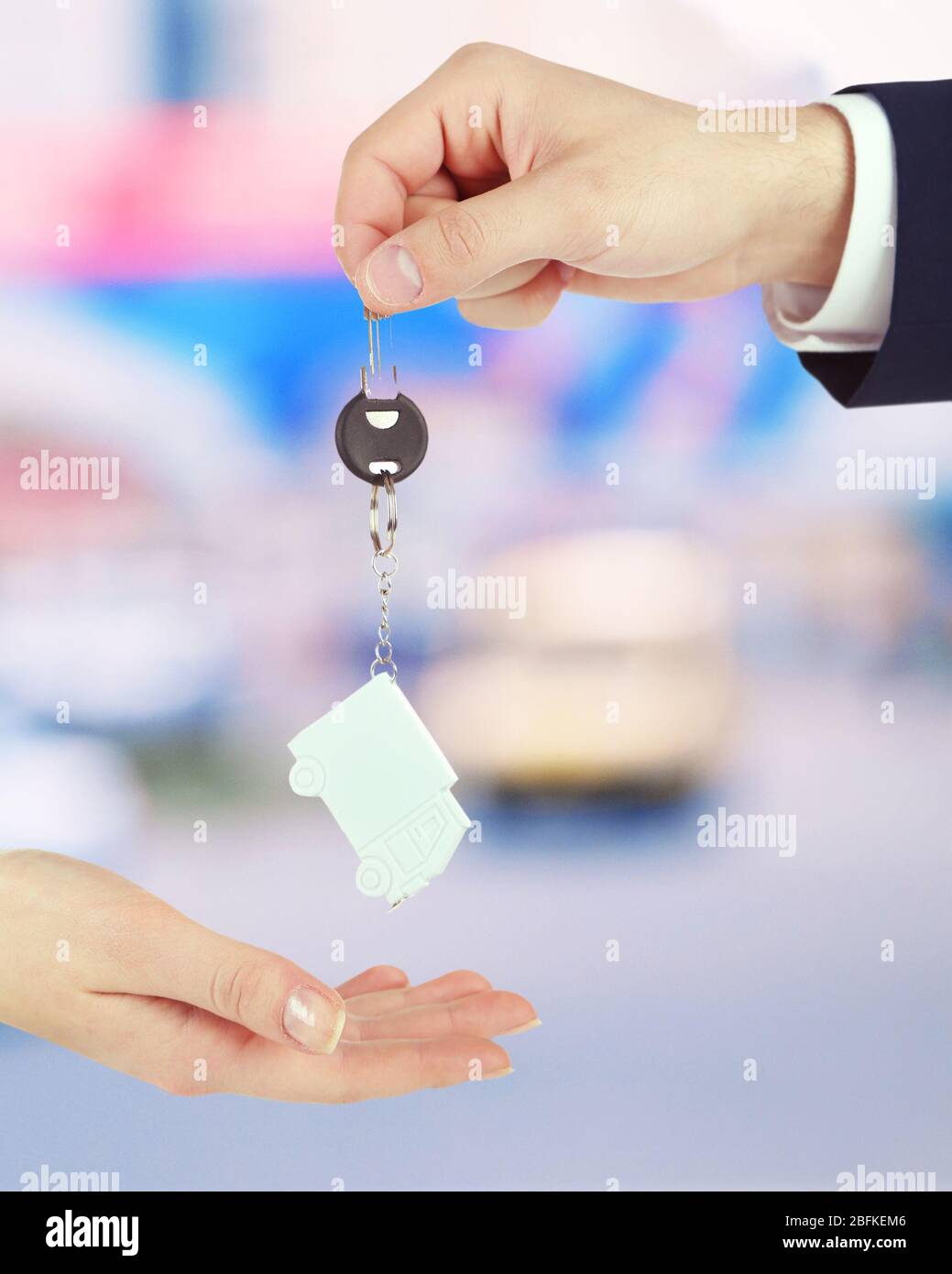 Keys in hand on blurred background store Stock Photo - Alamy