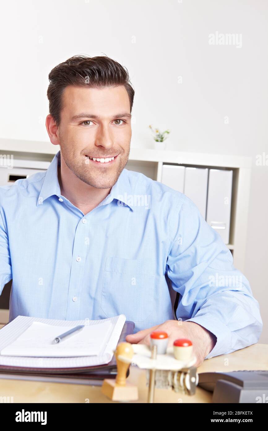 Manager with files and documents in front of him works at the desk in ...