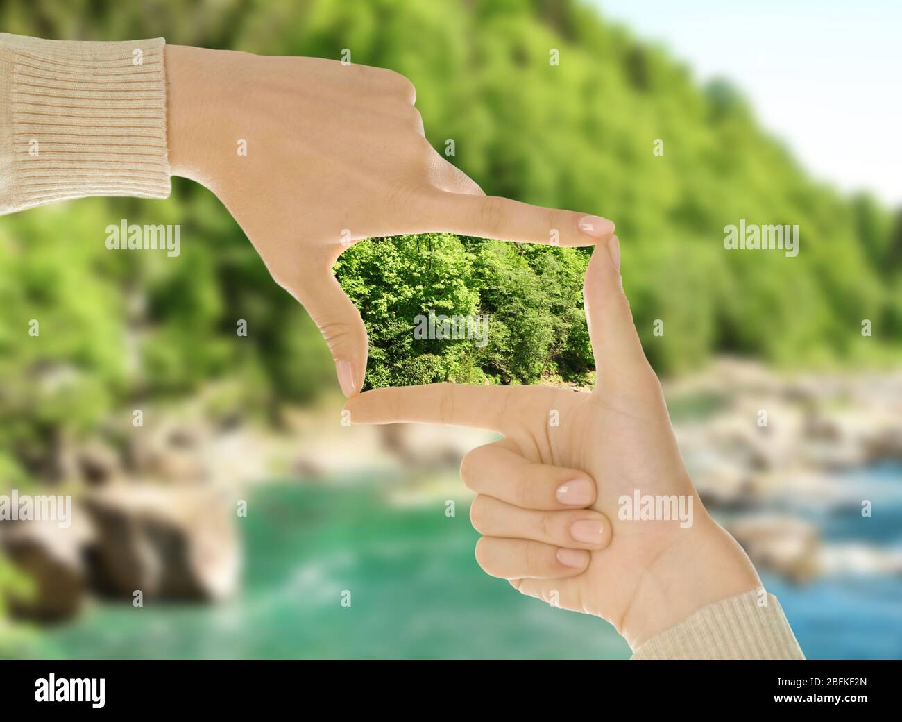 Woman holds hands in the shape of a frame on nature background Stock ...