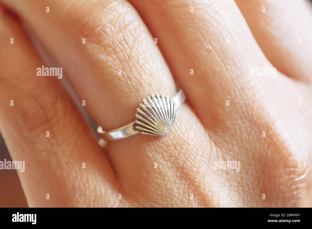 Hand wearing elegant silver ring in the shape of the shell Stock Photo ...