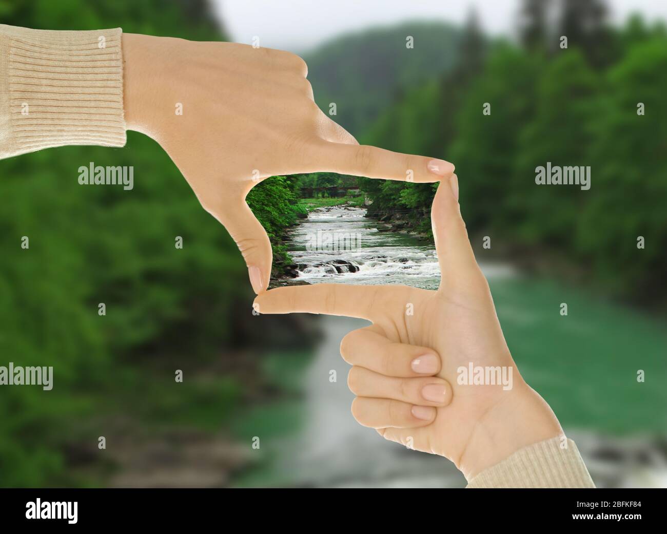 Woman holds hands in the shape of a frame on nature background Stock ...